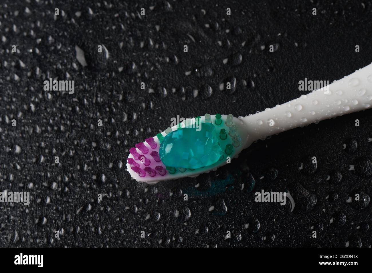Toothbrush with toothpaste on black background with water drops Stock ...