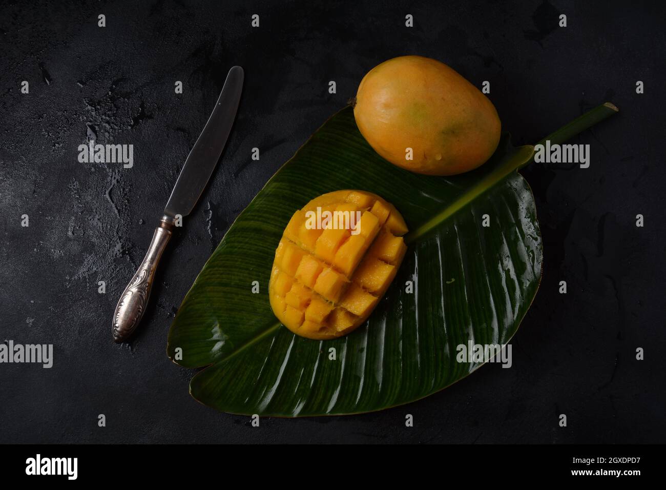 Fresh mango fruit with sliced diced mango chunks on a plate or on ...