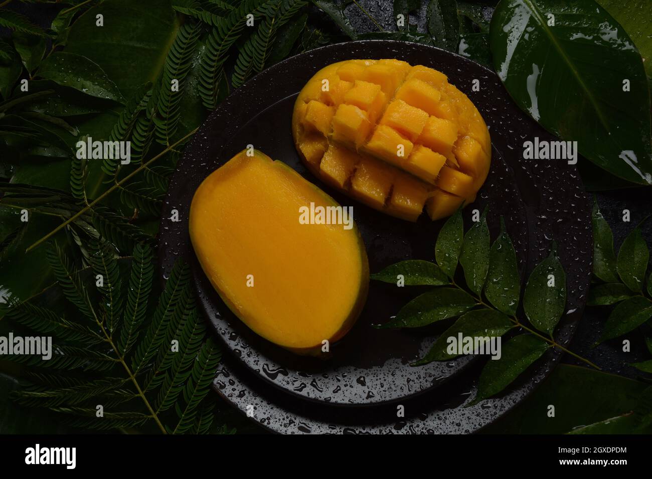 Fresh mango fruit with sliced diced mango chunks on a plate or on ...