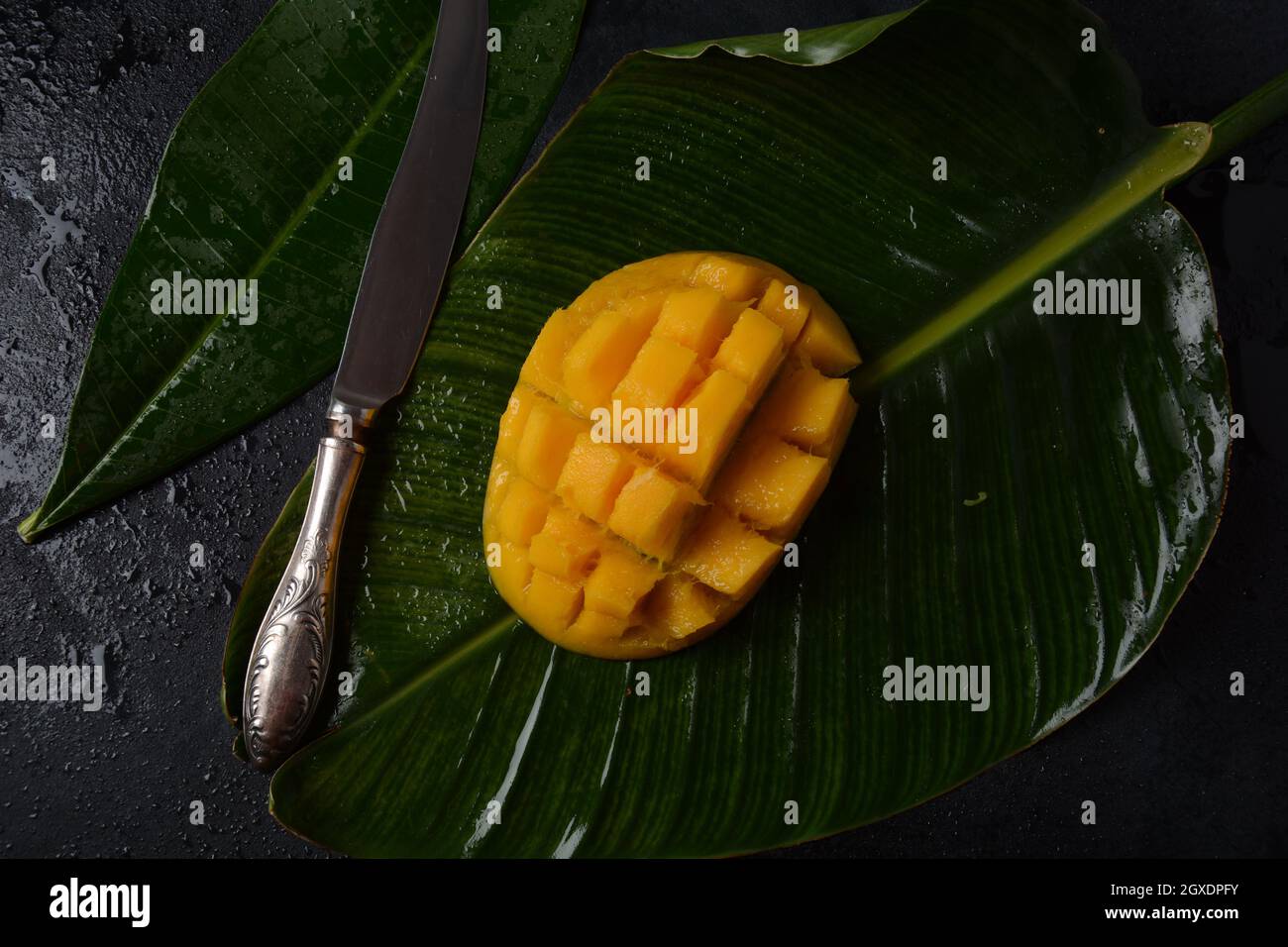 Fresh mango fruit with sliced diced mango chunks on a plate or on ...