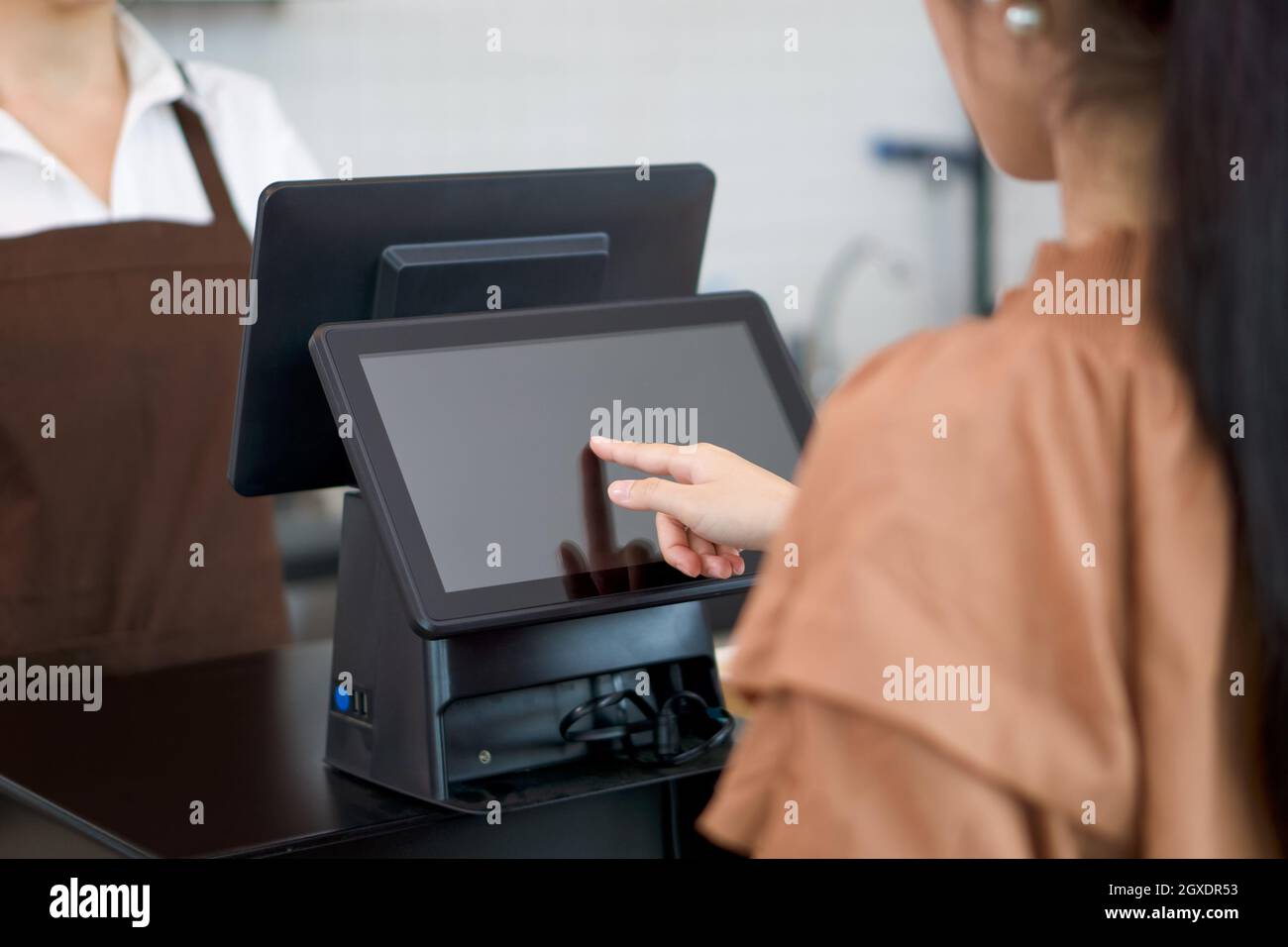 Young asian customer orders a beverage menu by choosing from a computer ...