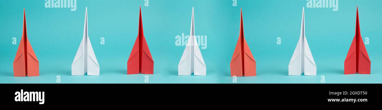 Paper airplanes in different colors on a white background, standing out ...