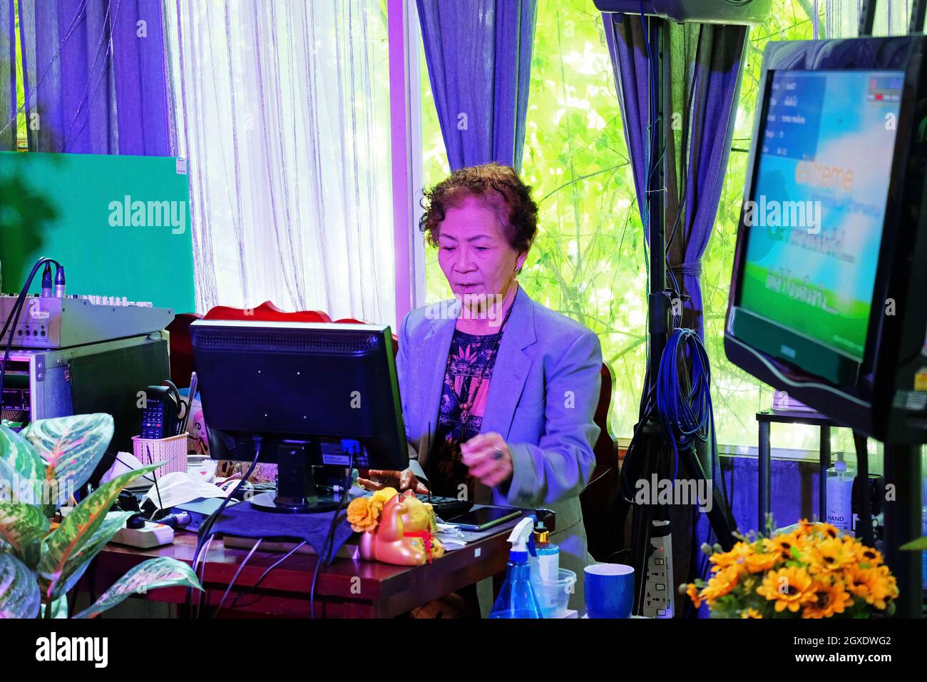 An old woman arranges music audio visual instruments in a Karaoke ...