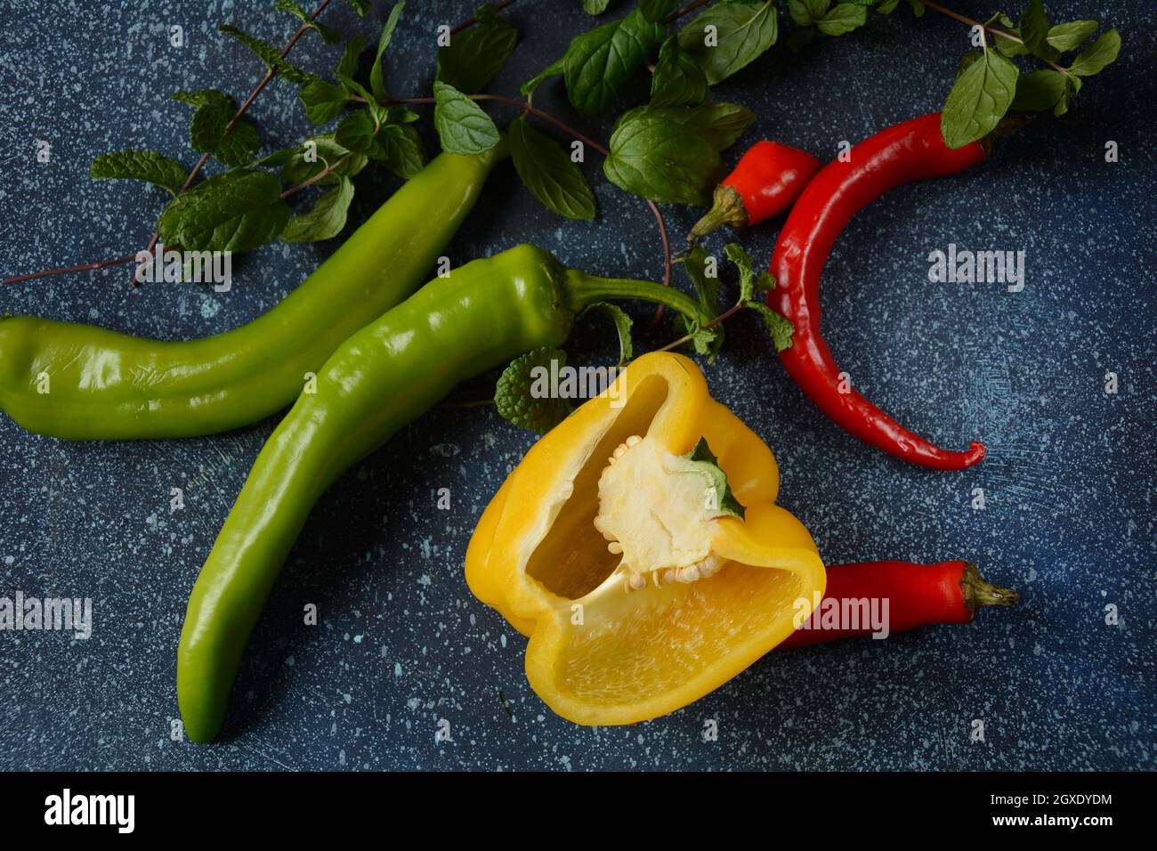Red and green chilly peppers and half of yellow bell-pepper Stock Photo ...