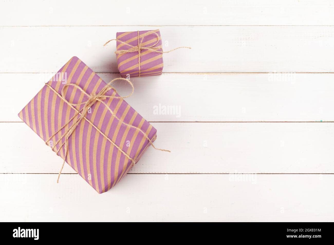 Tied bows gift boxes on white wooden background, top view Stock Photo - Alamy