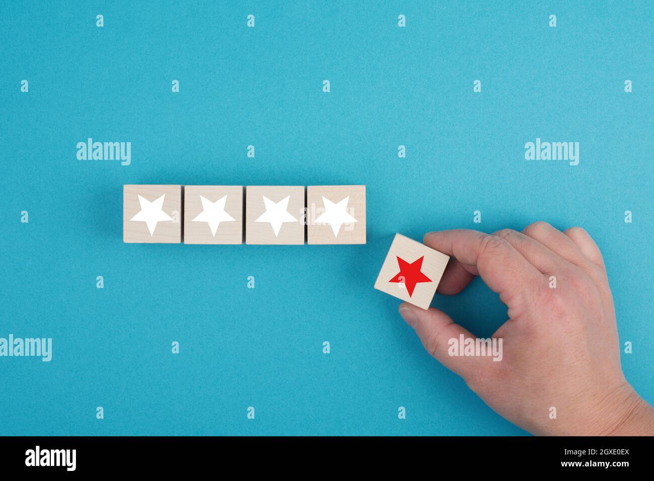 Wooden cubes with white stars, one block with a red star holding in the ...