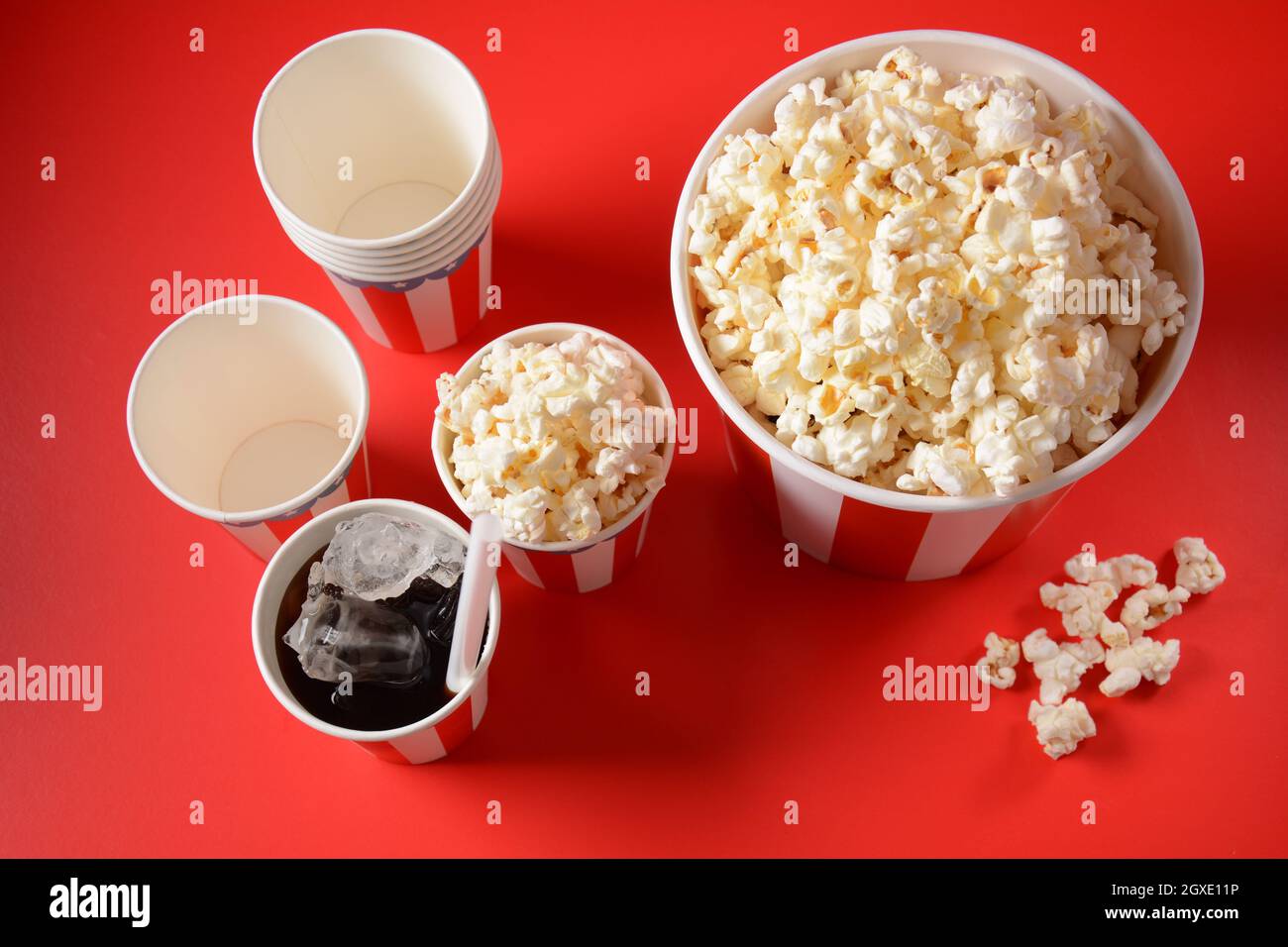 Buckets with delicious popcorn on red background and a glass of Cola ...