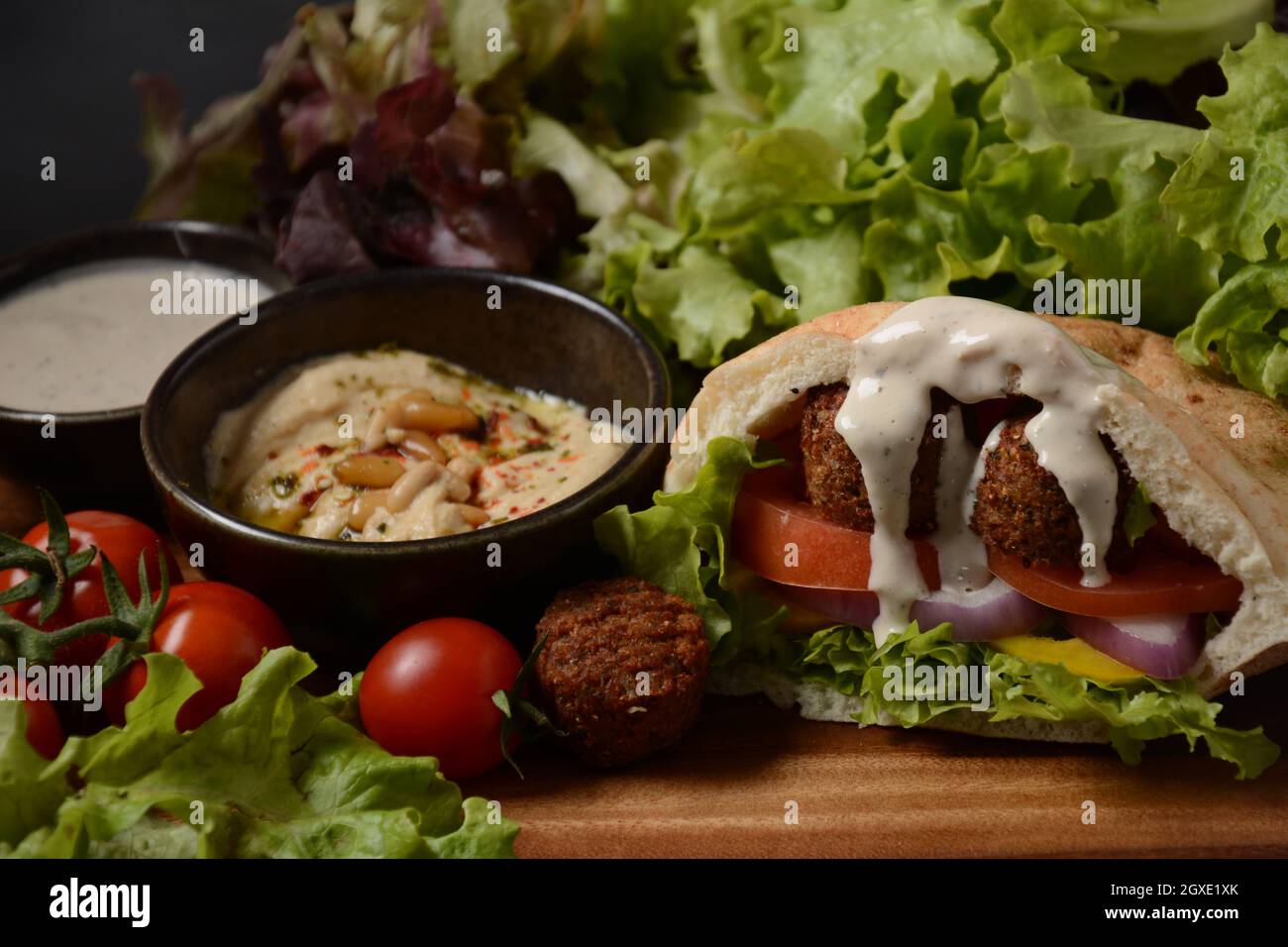 Falafel in pita bread with vegetable salad, harissa sauce, humus ...