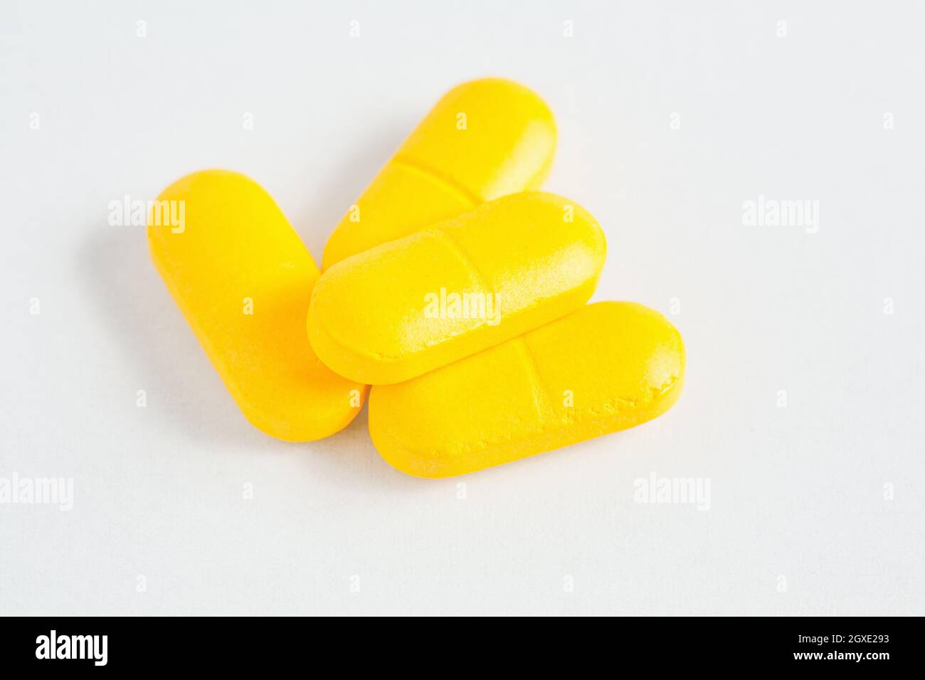 bunch of yellow capsules on white background Stock Photo - Alamy