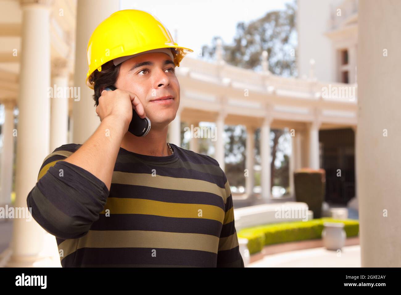 Handsome Hispanic Contractor with Hard Hat Talking on His Cell Phone ...