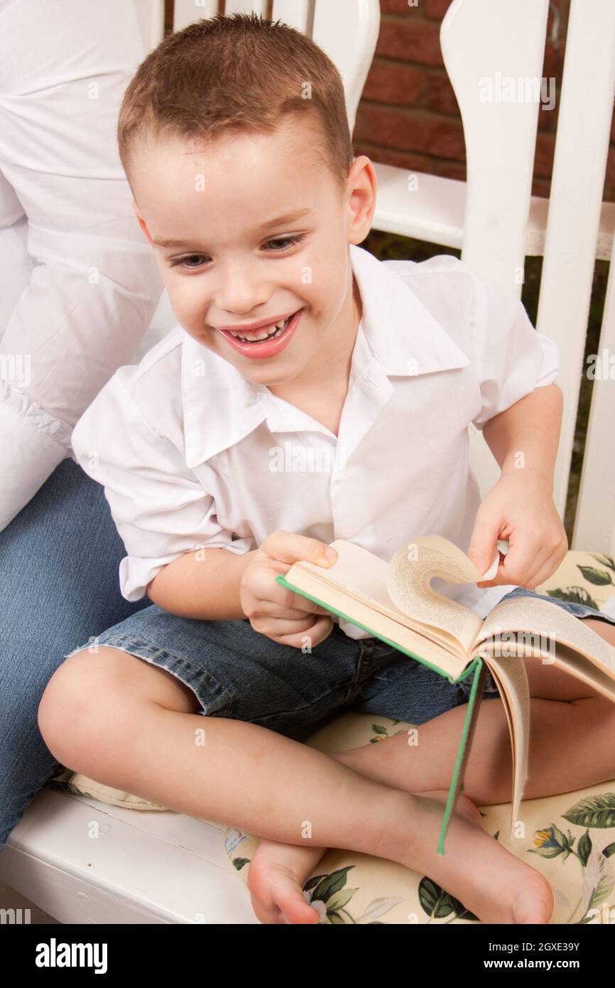 Cute Young Boy Reading His Book Indoors Next to His Mom Stock Photo - Alamy