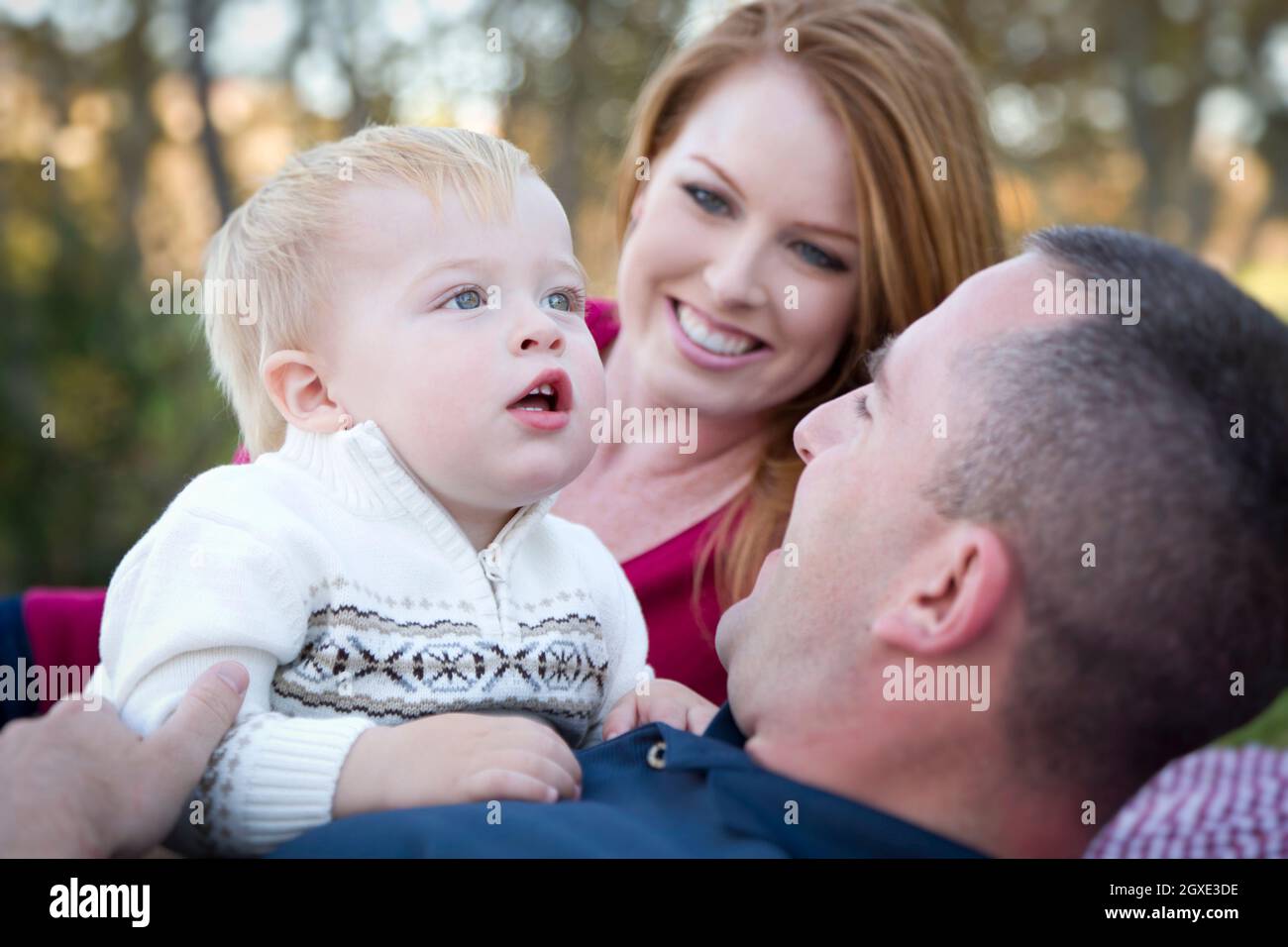 Cute Child Boy Looks Up to the Sky as Young Parents Smile Stock Photo ...