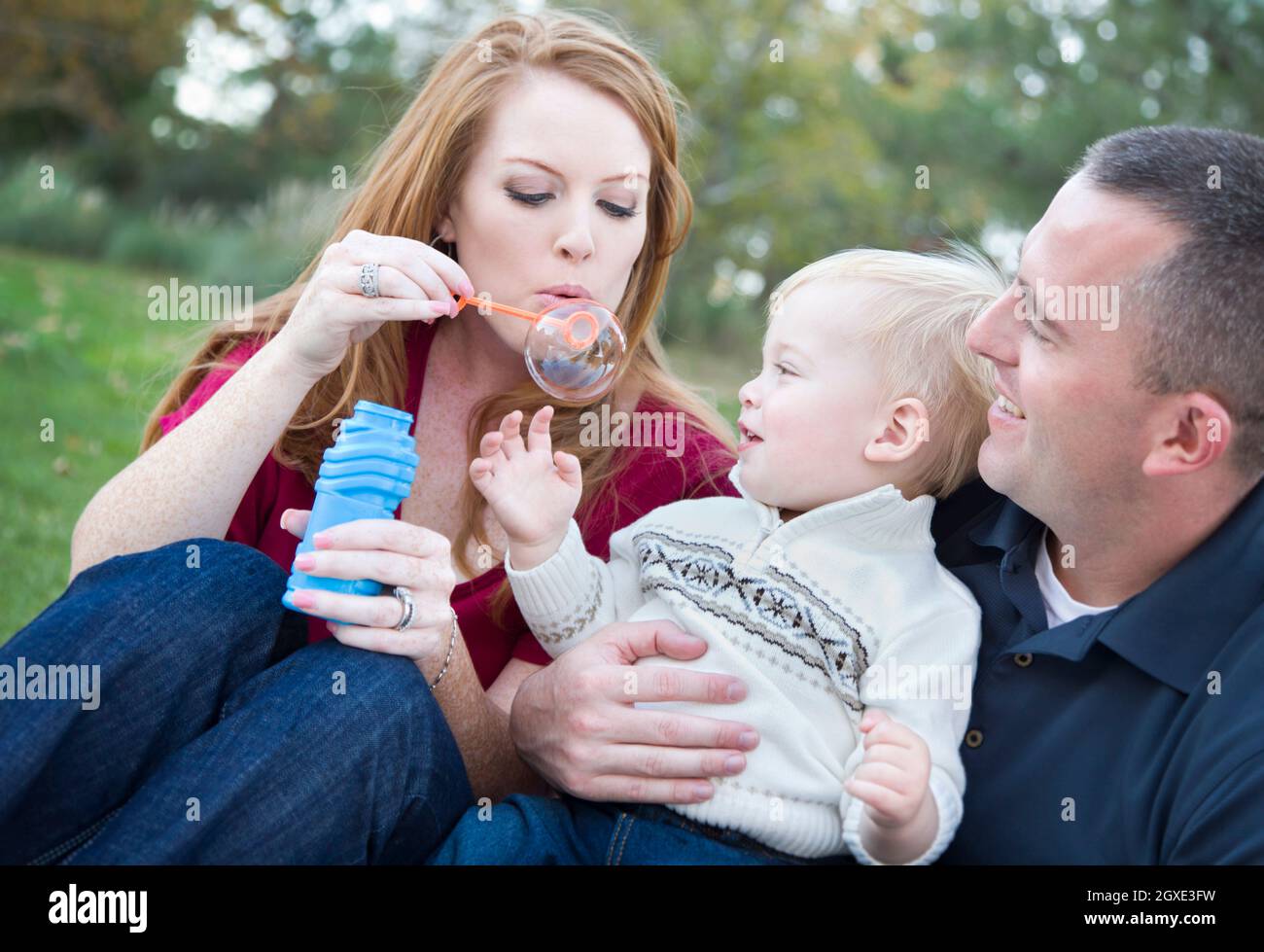 Attractive Young Parents Having Fun Blowing Bubbles with their Child ...