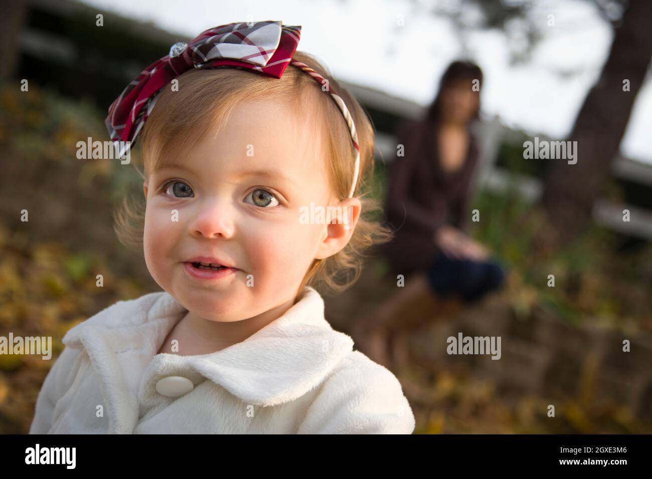 Adorable Baby Girl Playing Outside in the Park with Mom Behind Her ...