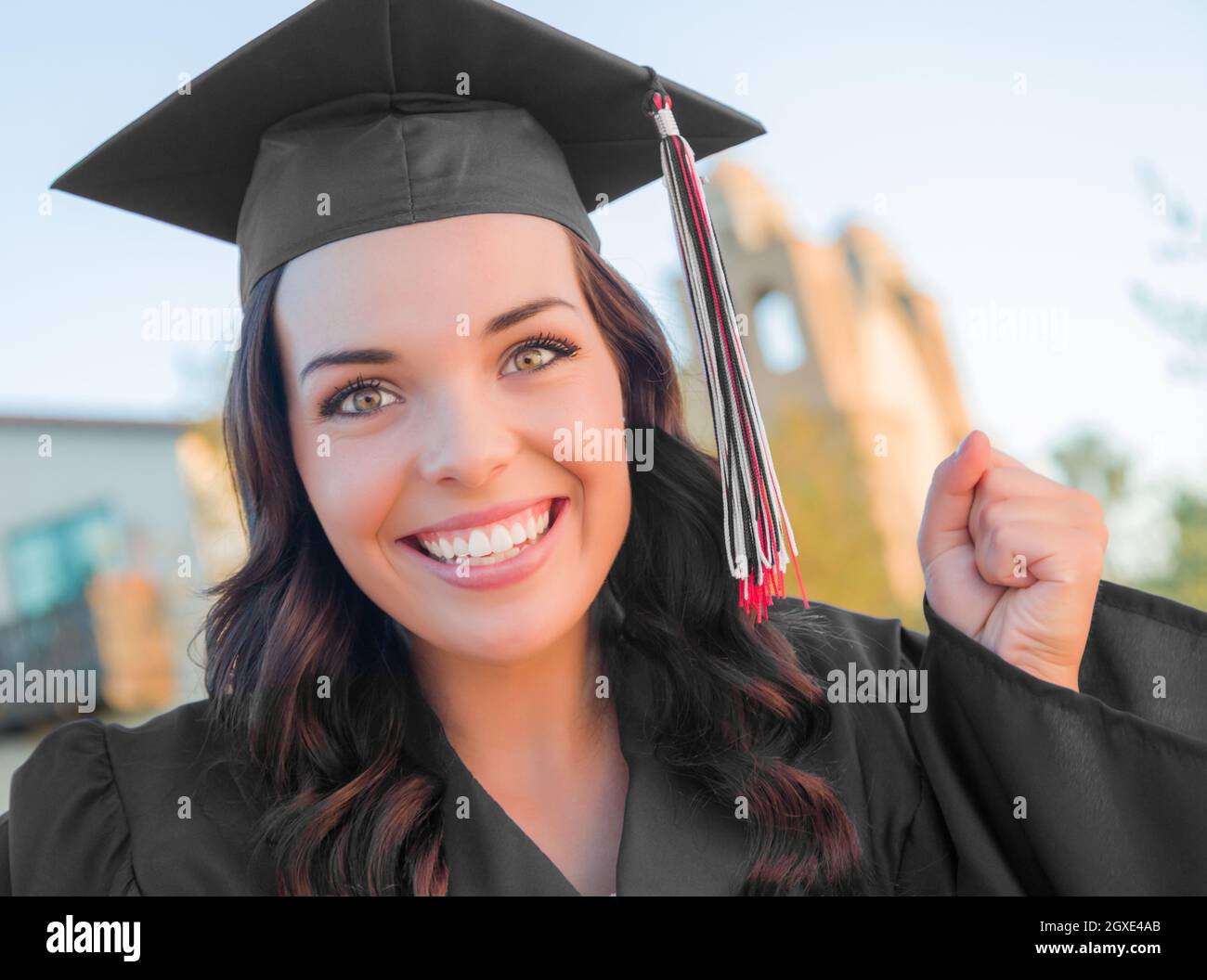 Happy Graduating Mixed Race Woman In Black Cap and Gown Celebrating on ...