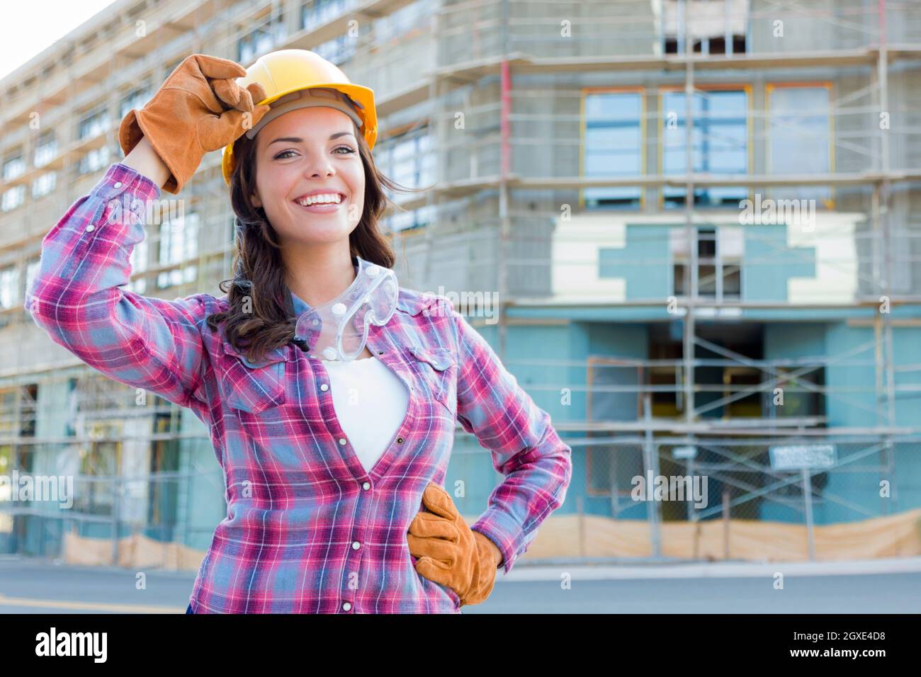 Portrait of Young Attractive Female Construction Worker Wearing Gloves, Hard Hat and Protective ...