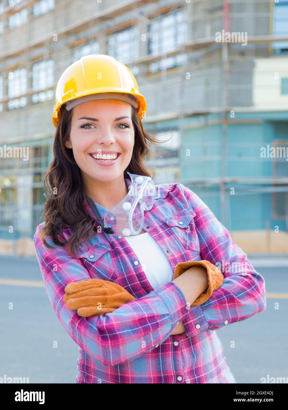 Portrait of Young Attractive Female Construction Worker Wearing Gloves, Hard Hat and Protective ...