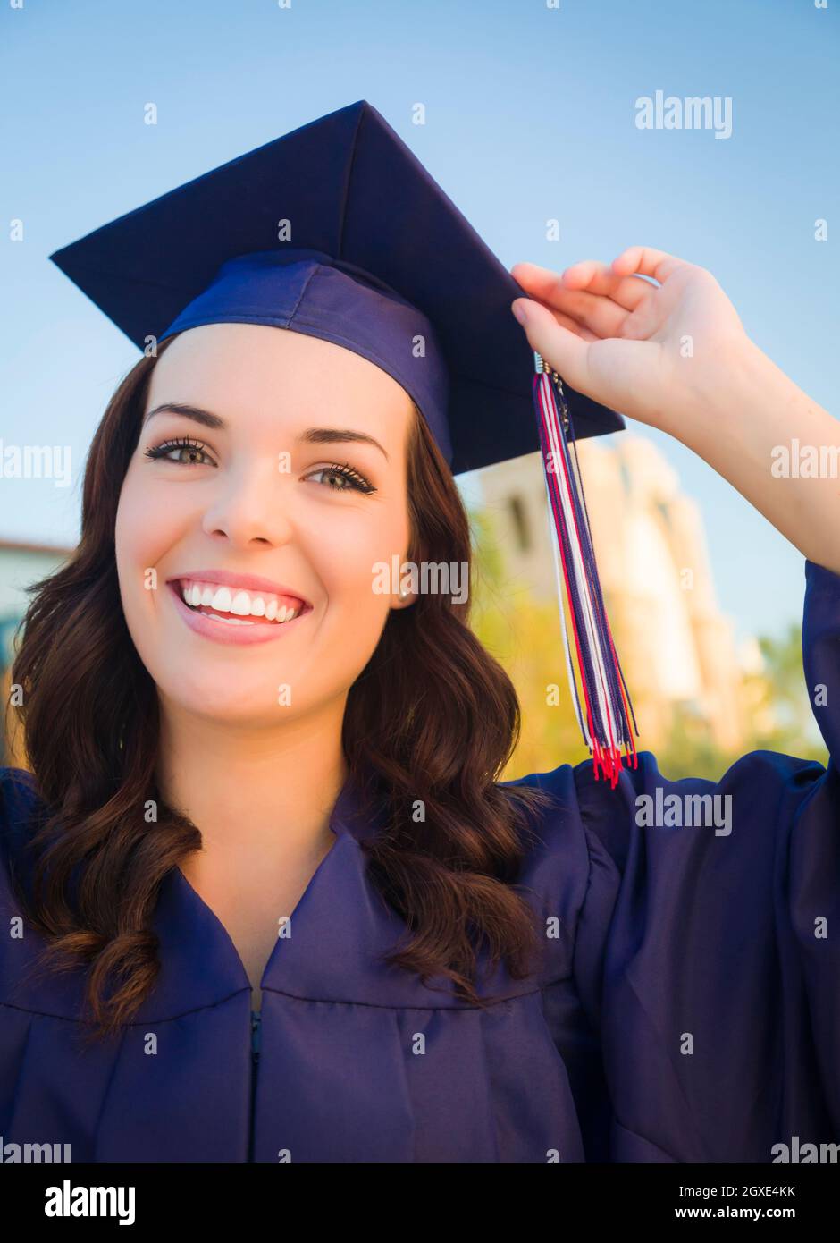 Happy Graduating Mixed Race Woman In Cap and Gown Celebrating on Campus ...
