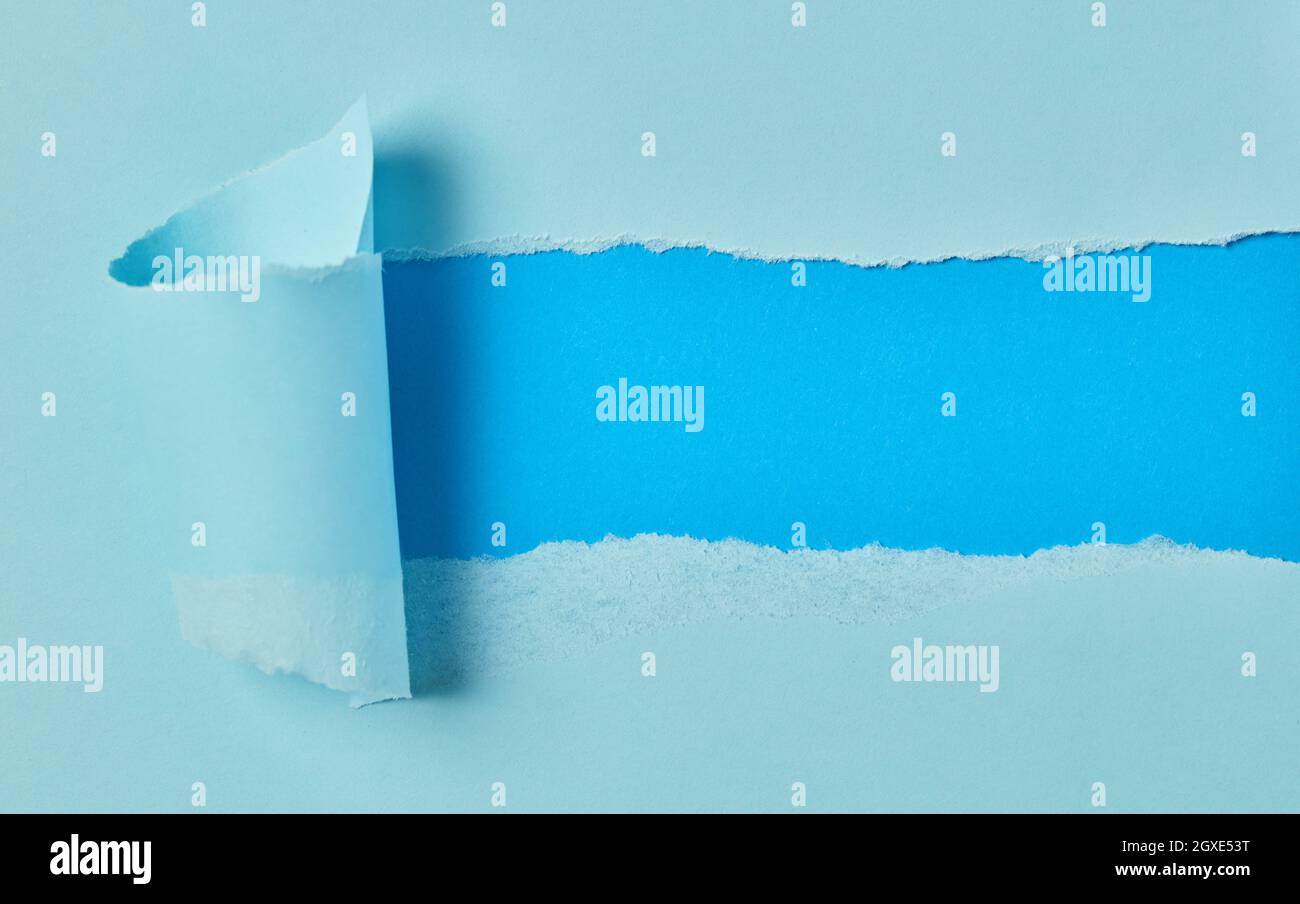 Blue ripped paper curled up Stock Photo - Alamy