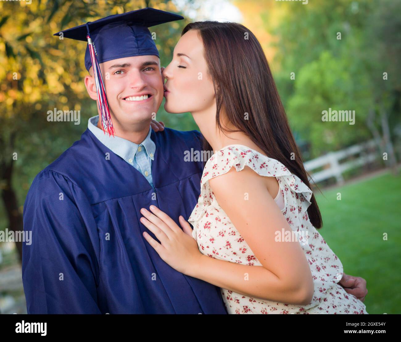Happy Male Graduate in Cap and Gown and Pretty Girl Celebrate Outside ...
