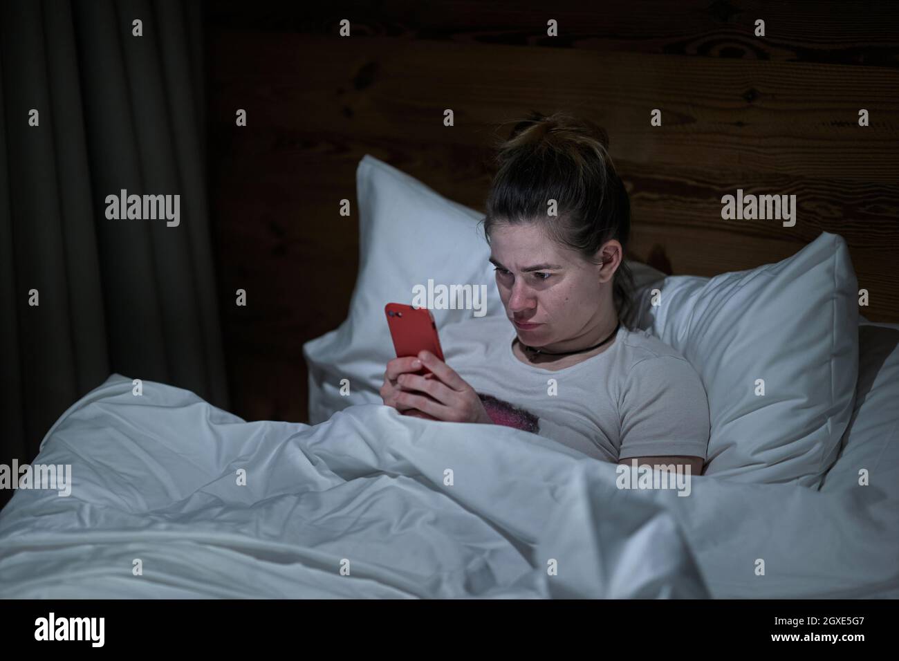 Staring at smartphone late at night in bed, lack of sleep Stock Photo ...