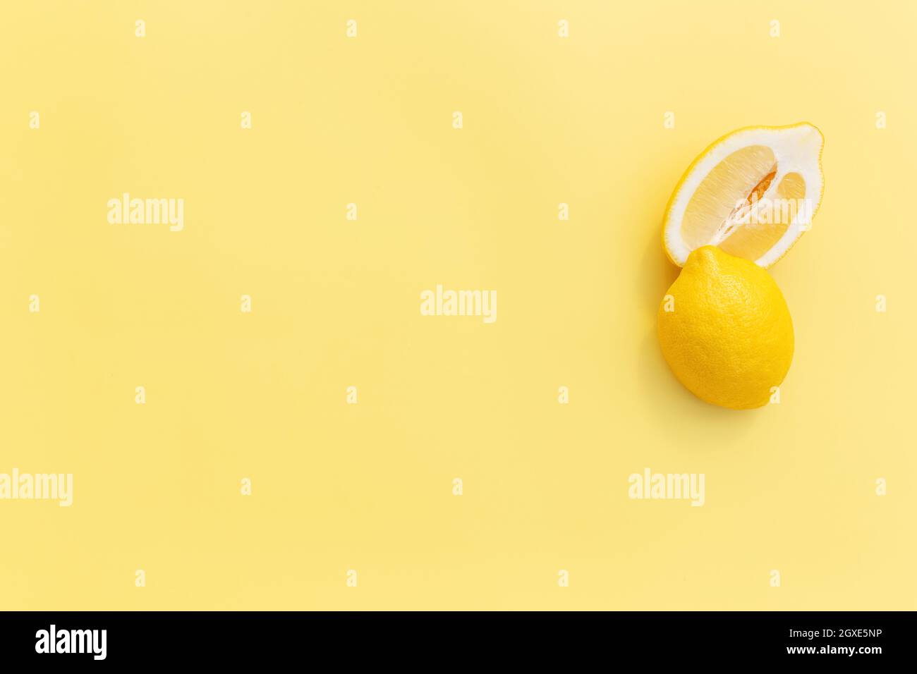 Two halved cuts of lemon with shadow on yellow background. Healthy ...