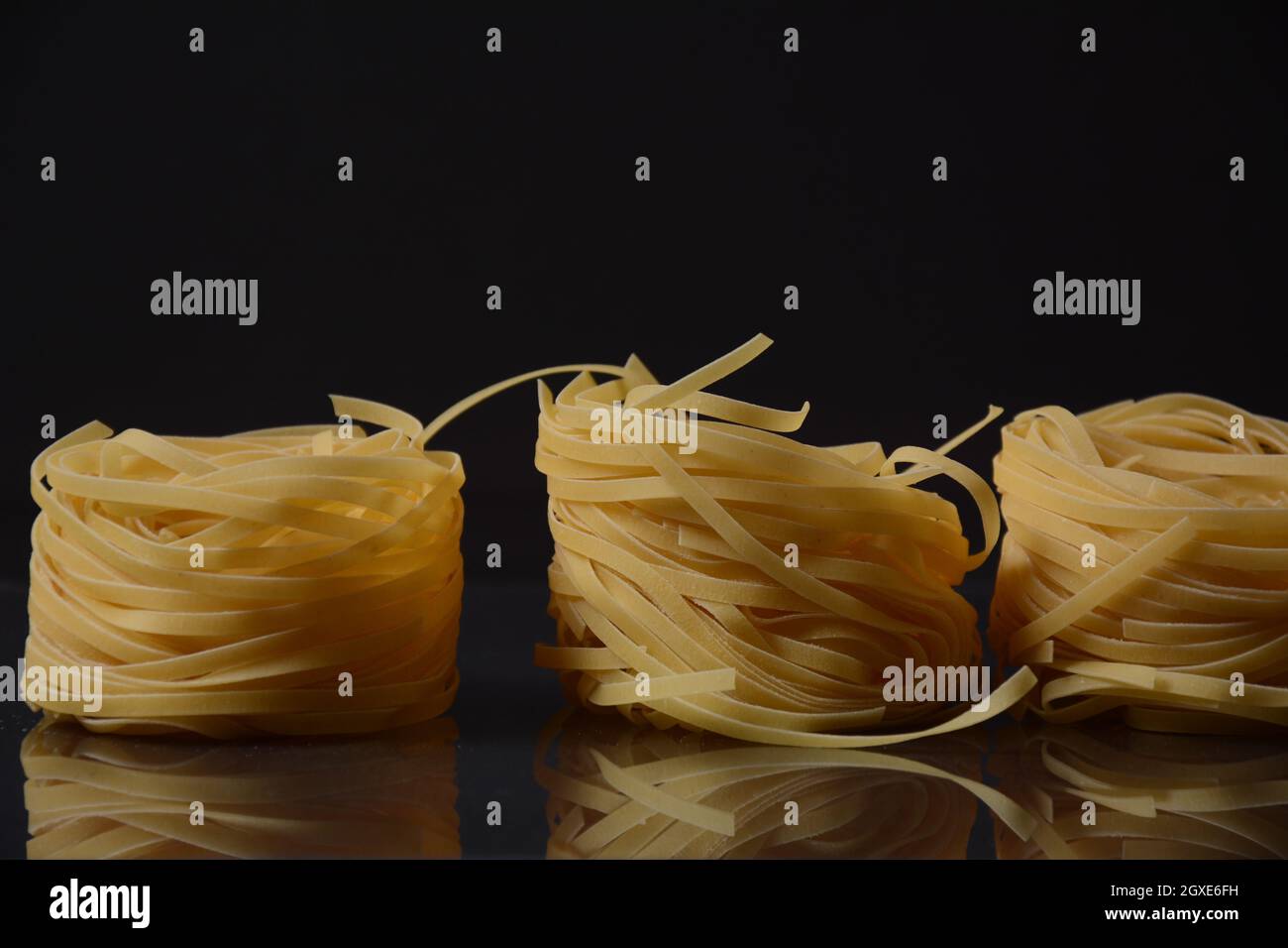 Uncooked tagliatelle. Italian food ingredients for pasta Stock Photo ...