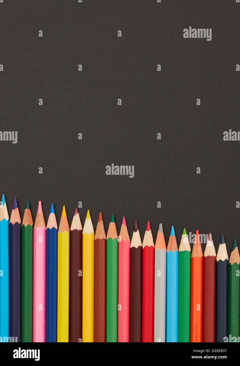 Multi-colored pencils on black background Stock Photo - Alamy