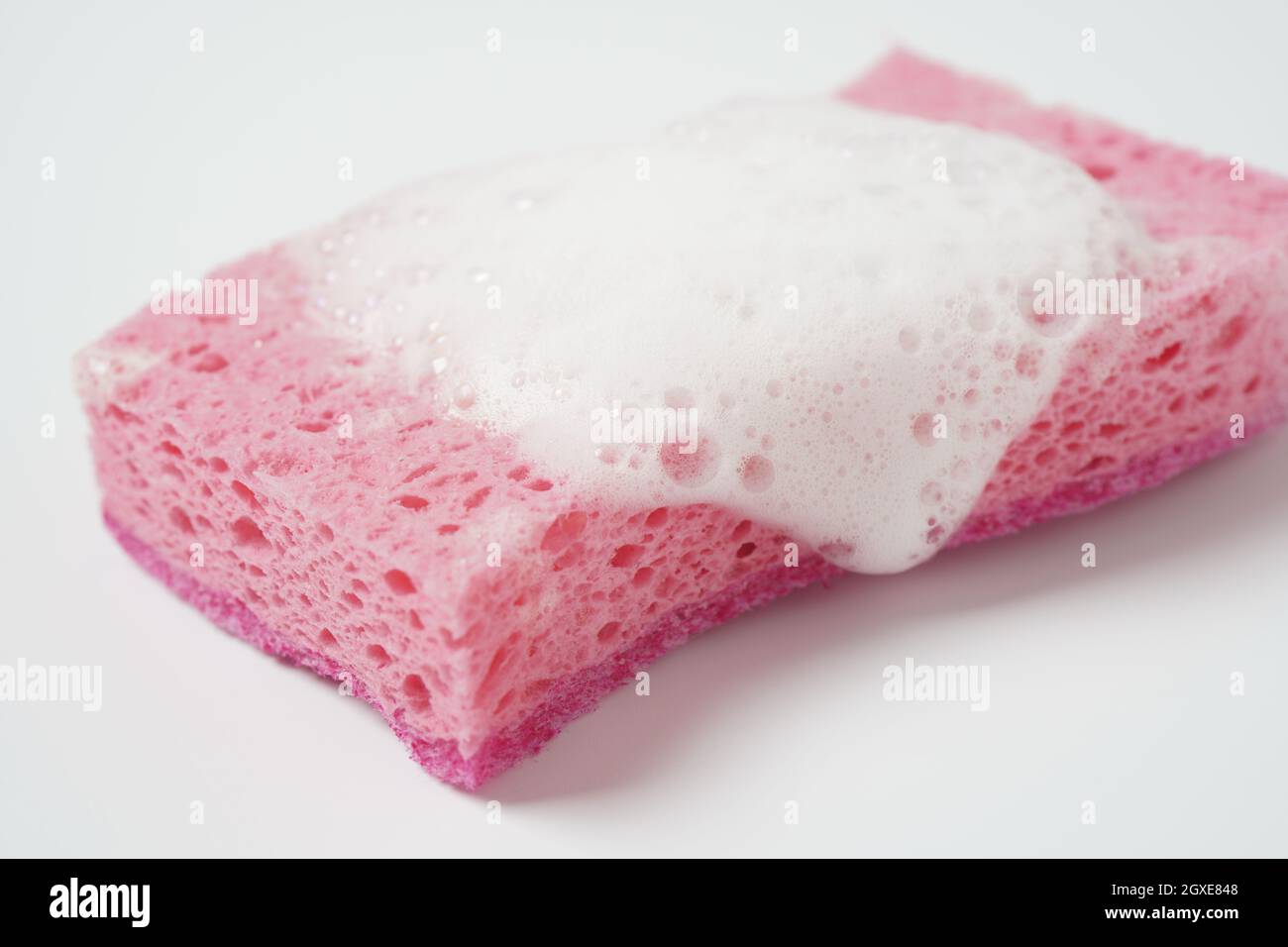 Pink cleaning sponge in soap foam on white background Stock Photo - Alamy