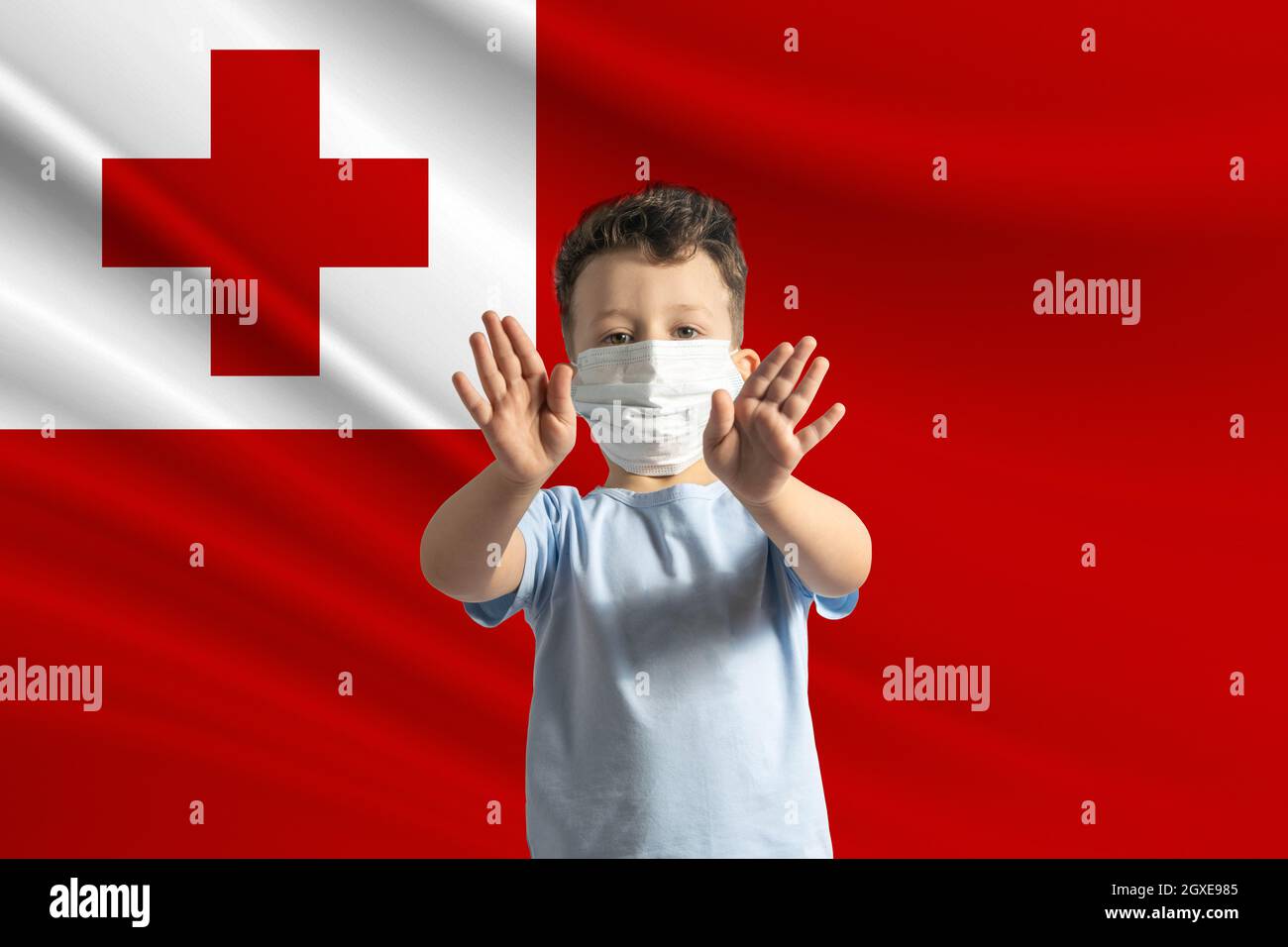 Little white boy in a protective mask on the background of the flag of ...