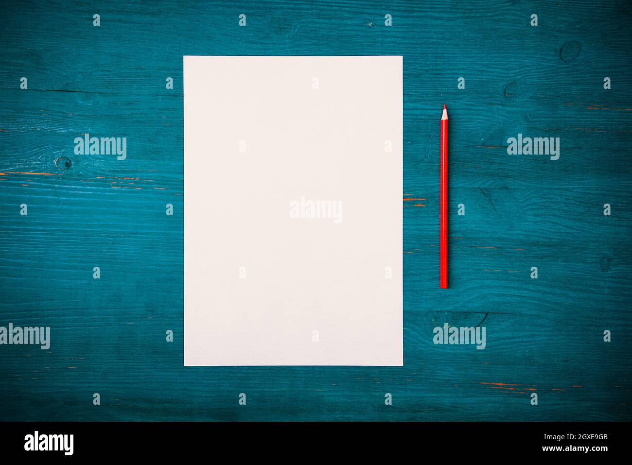A blank white sheet and pencil for drawing on a wooden background with ...