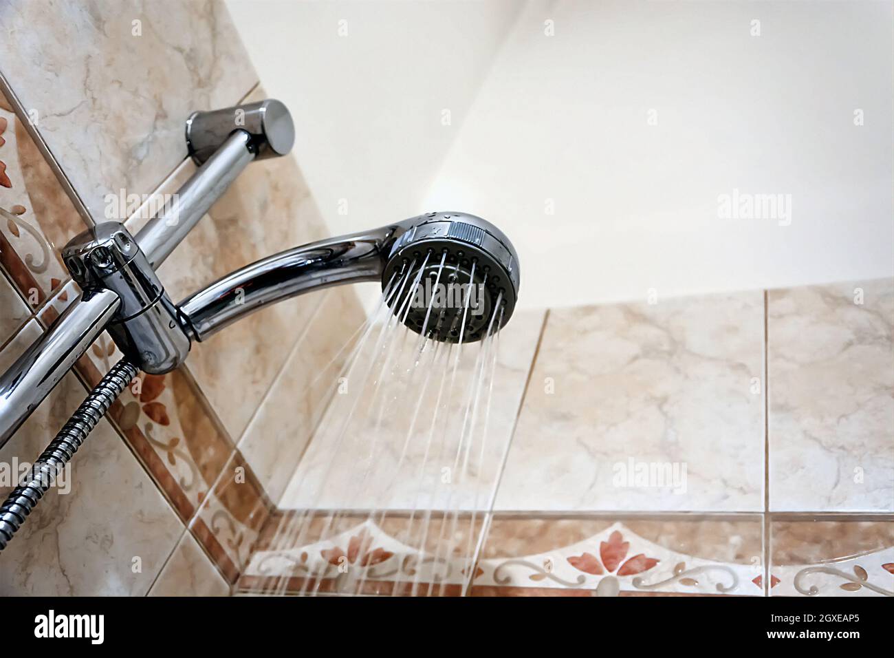 Interior of a shower with water flowing from the shower head. Droplets ...