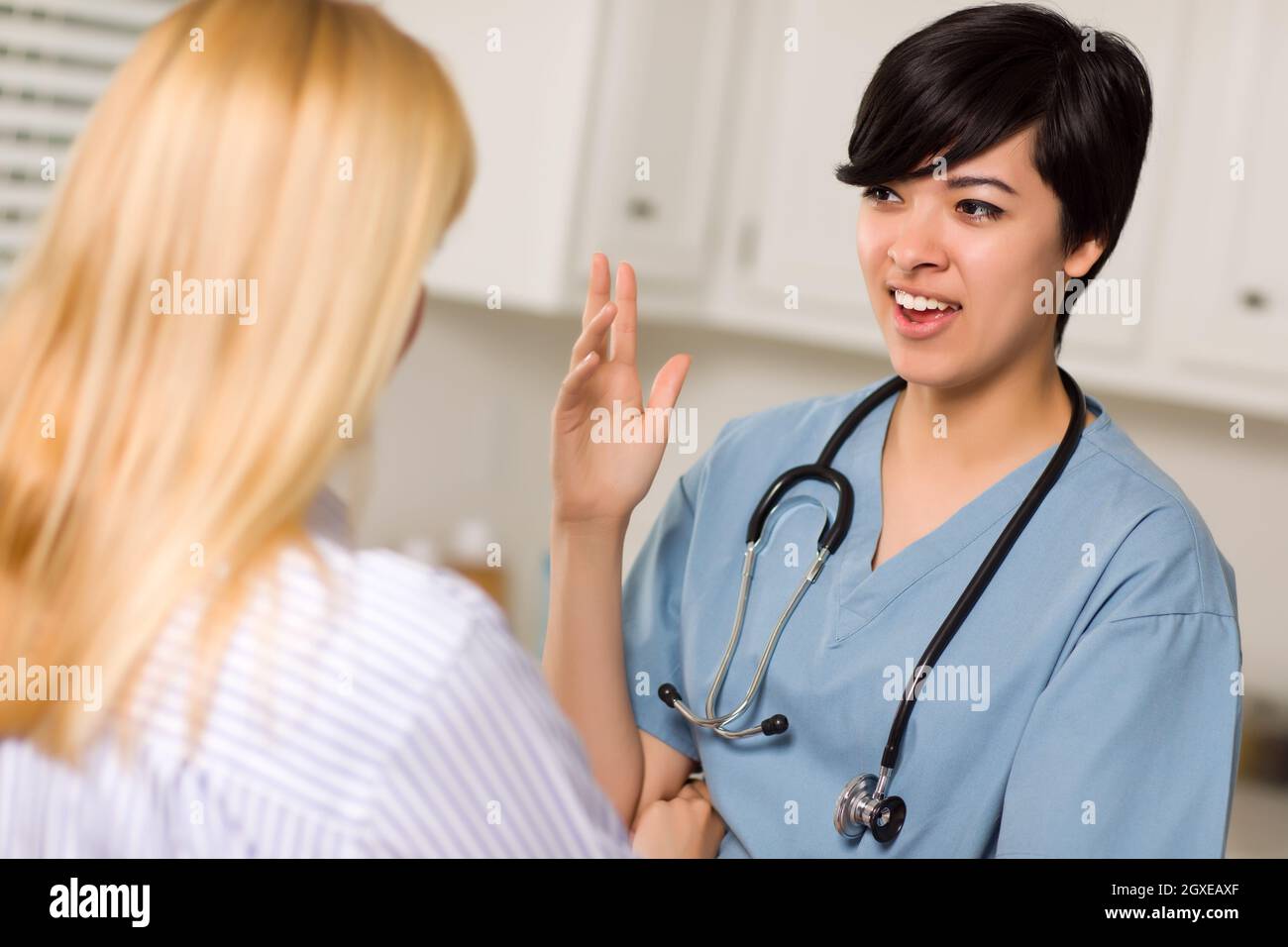 Attractive Mixed Race Young Female Doctor Talking with Patient in an ...