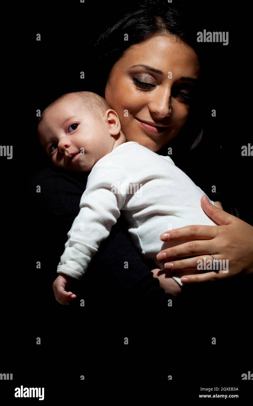Young Attractive Ethnic Woman Holding Her Newborn Baby Under Dramatic ...