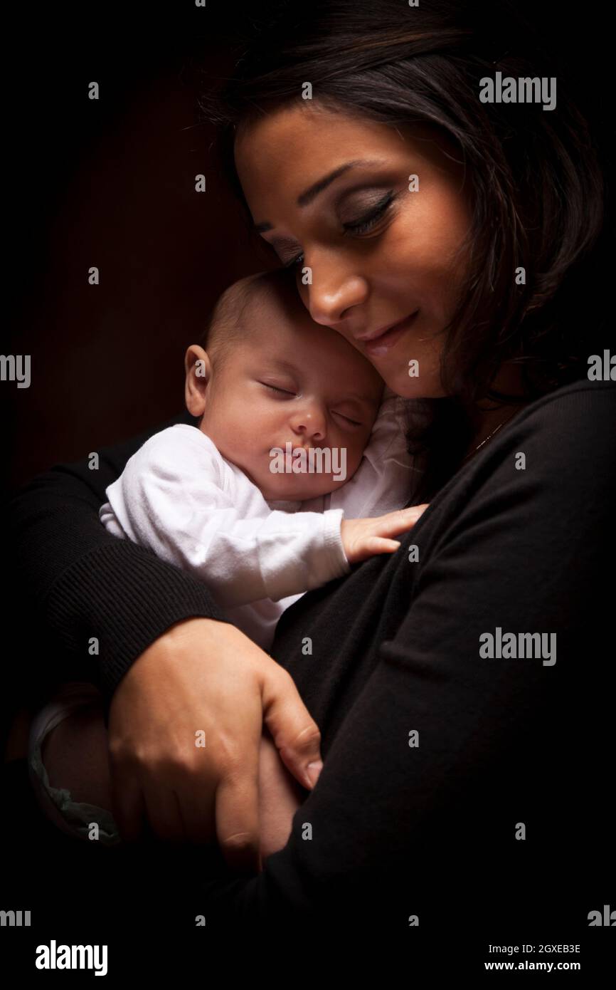 Young Attractive Ethnic Woman Holding Her Newborn Baby Under Dramatic ...