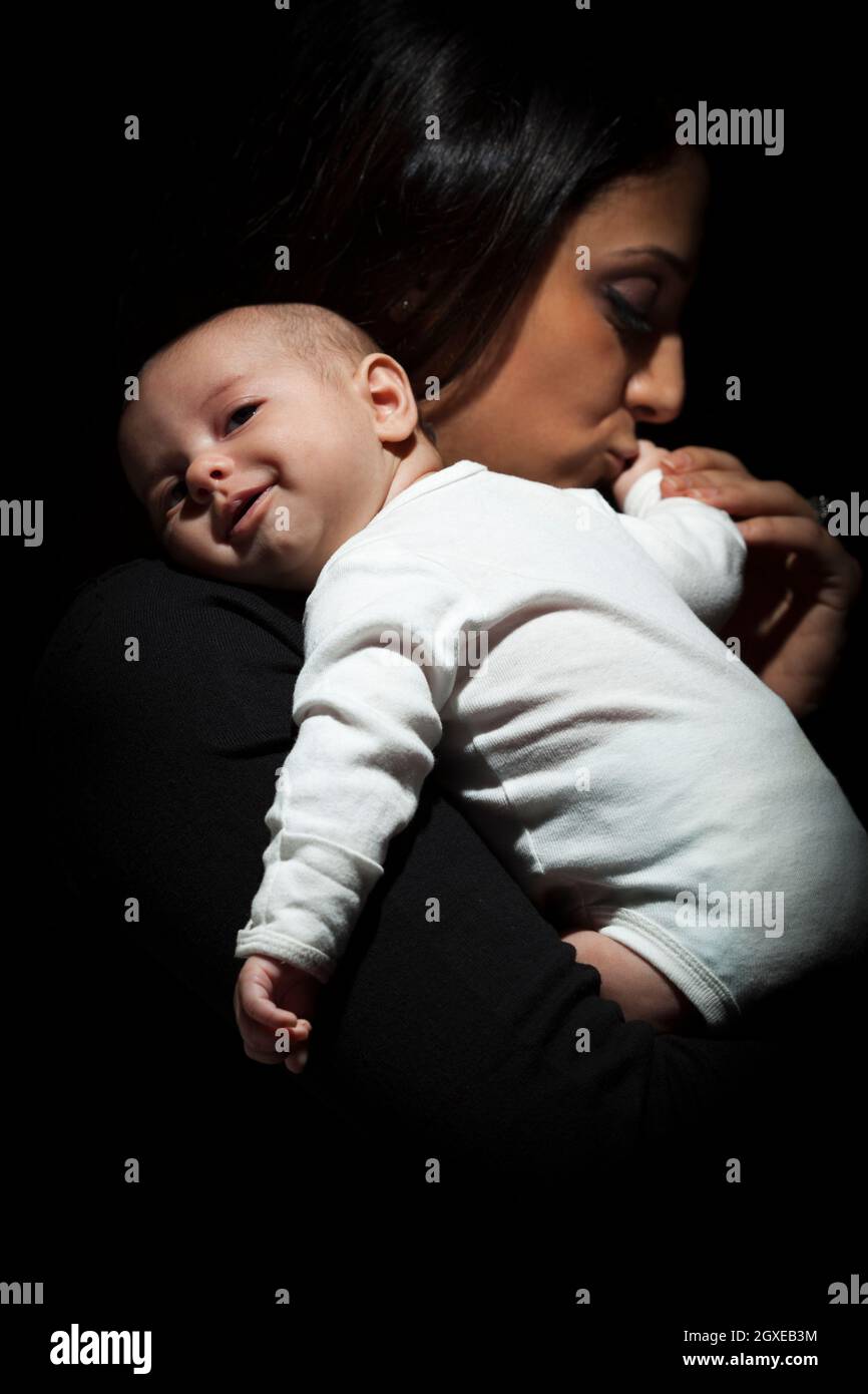 Young Attractive Ethnic Woman Kisses Her Newborn Baby Hand Under ...