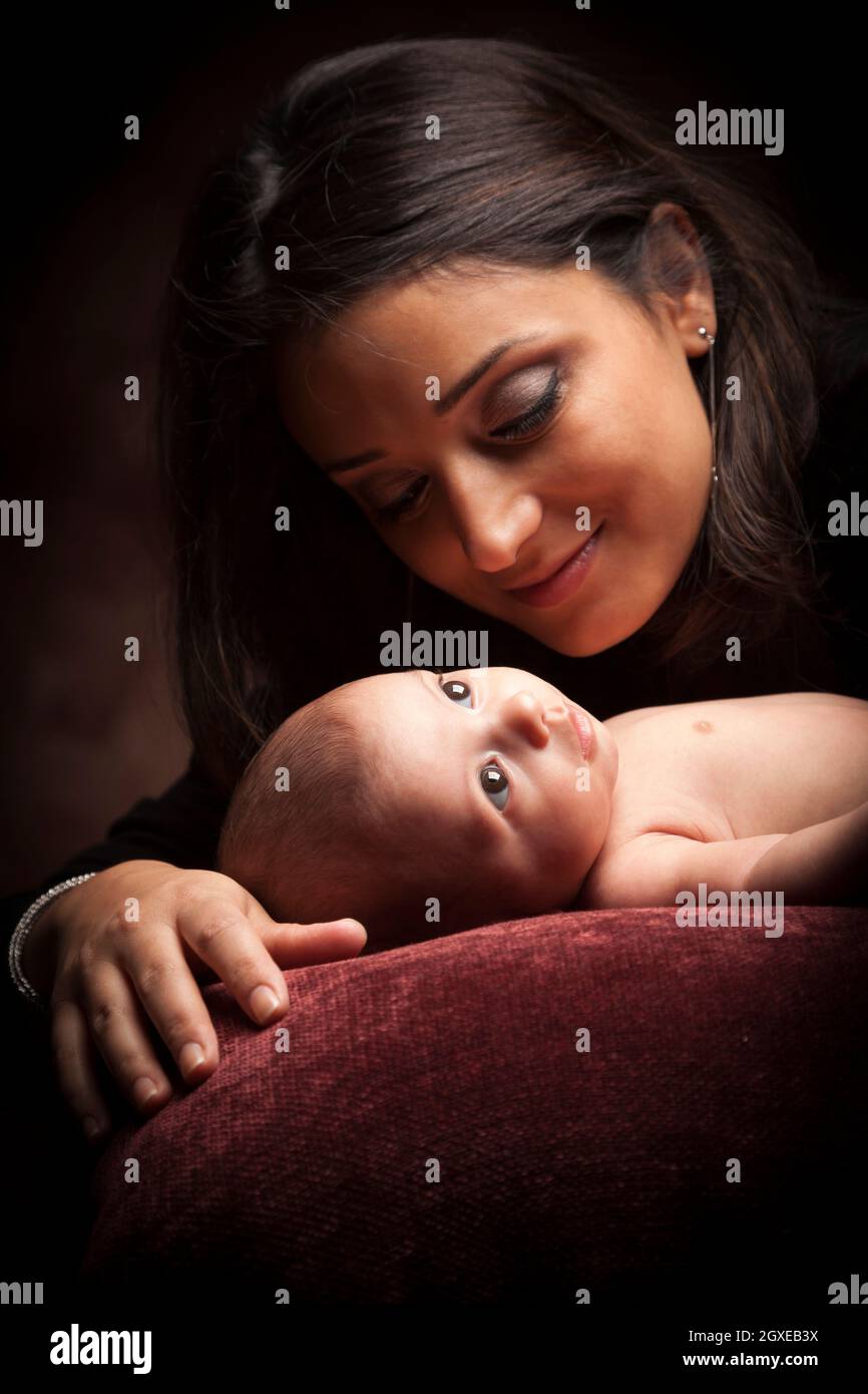 Young Attractive Ethnic Woman Holding Her Newborn Baby Under Dramatic ...