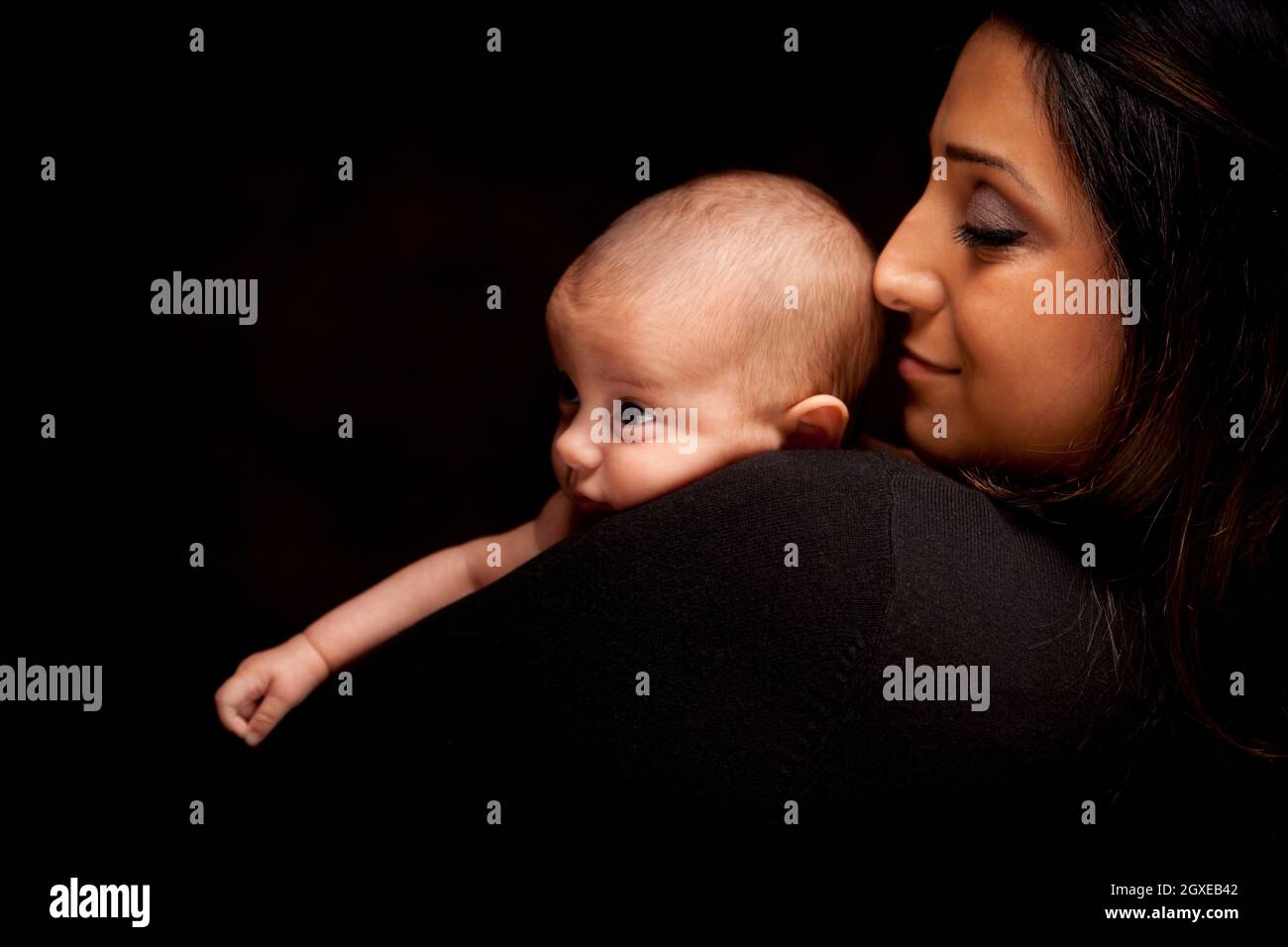 Young Attractive Ethnic Woman Holding Her Newborn Baby Under Dramatic ...