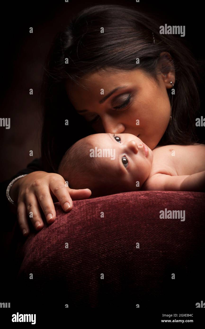 Young Attractive Ethnic Woman Holding Her Newborn Baby Under Dramatic ...