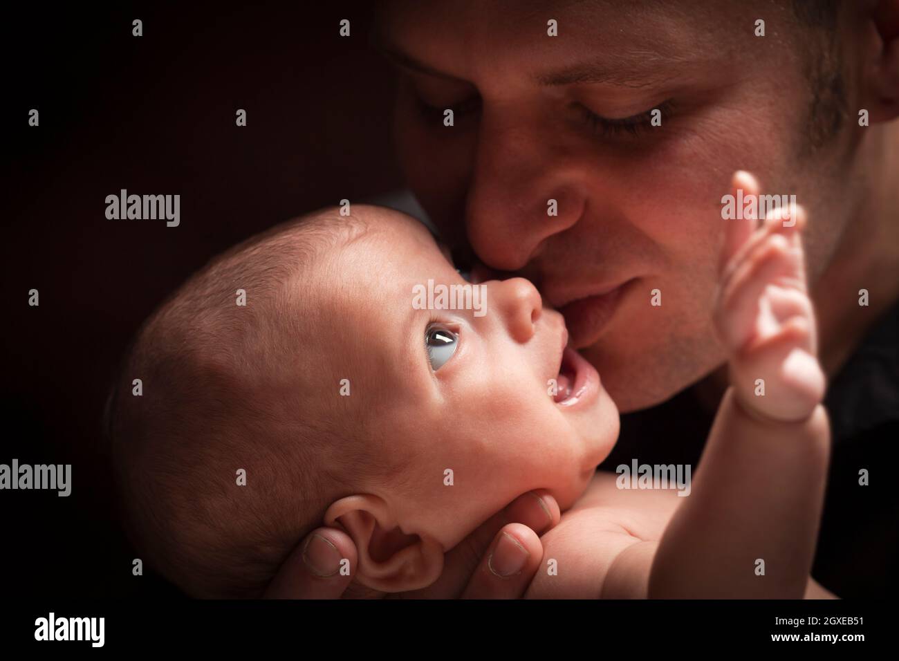Happy Young Father Holding His Mixed Race Newborn Baby Under Dramatic ...