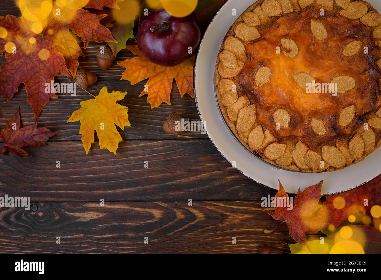 Autumn background with pumpkin cake, maple leaves, aples and acorns ...