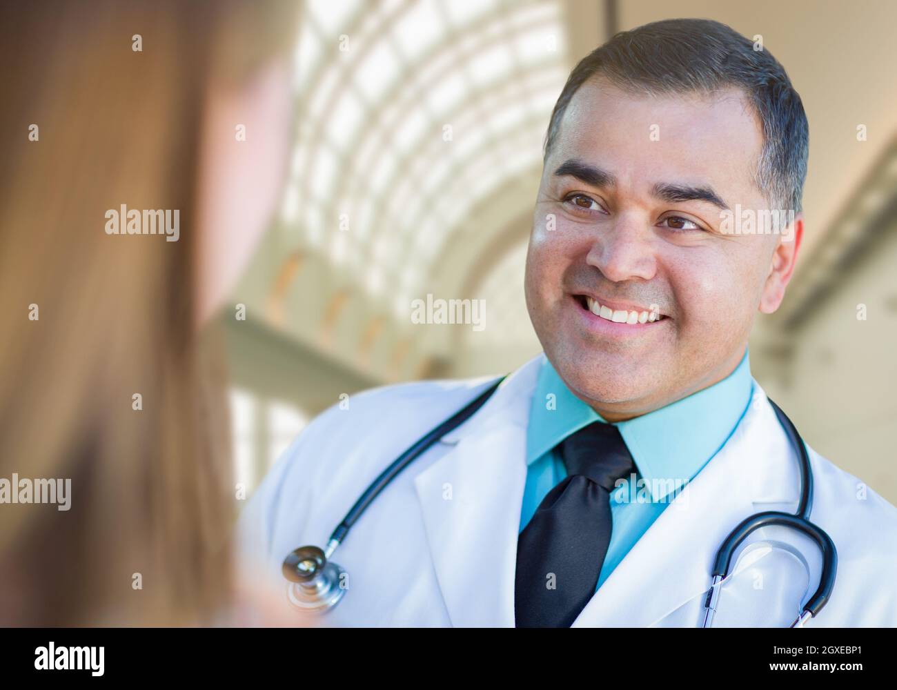Hispanic Male Doctor or Nurse Talking With a Patient Inside Hospital ...