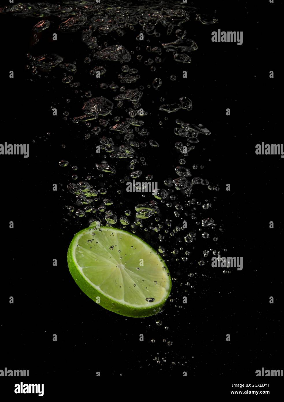 Lime splashing in water on a black background Stock Photo - Alamy