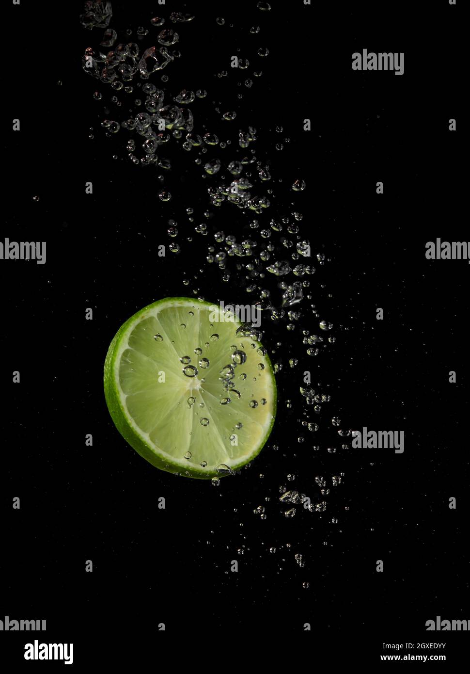 Lime splashing in water on a black background Stock Photo - Alamy