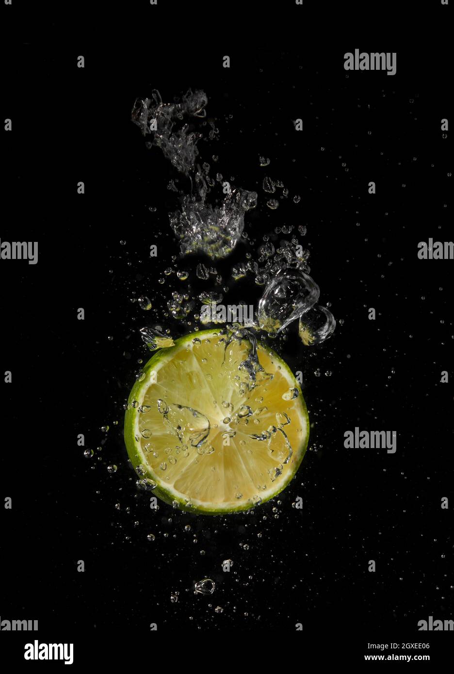 Lime splashing in water on a black background Stock Photo - Alamy
