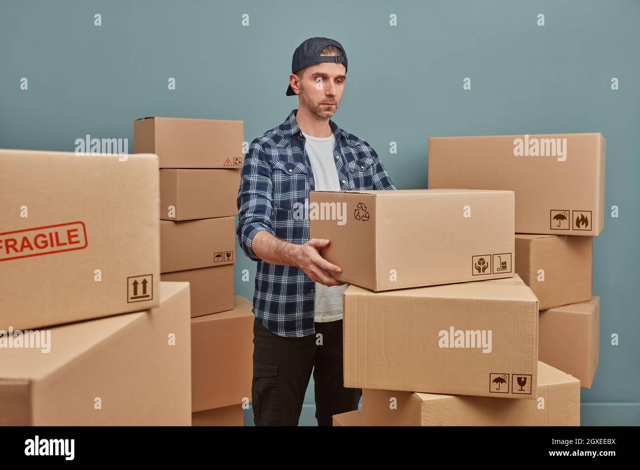 Man organizing cardboard boxes Stock Photo - Alamy