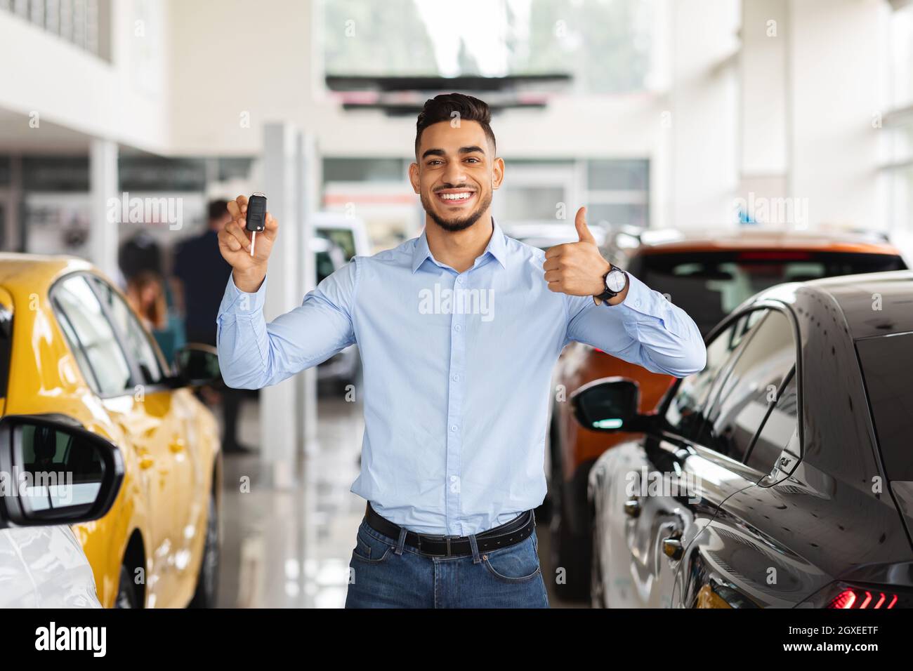 Handsome arabic guy showing car key and thumb up Stock Photo - Alamy