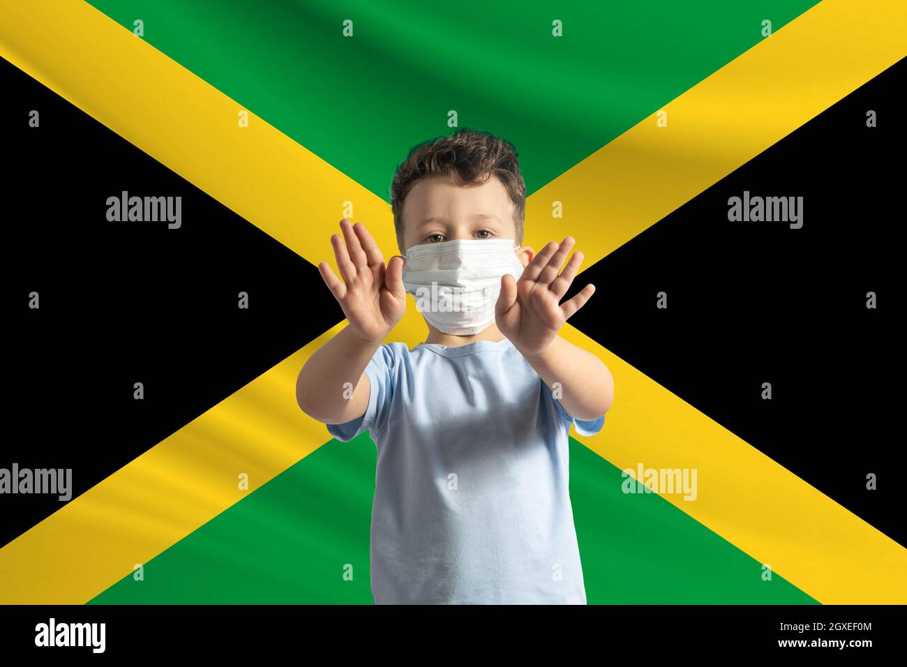 Little white boy in a protective mask on the background of the flag of ...