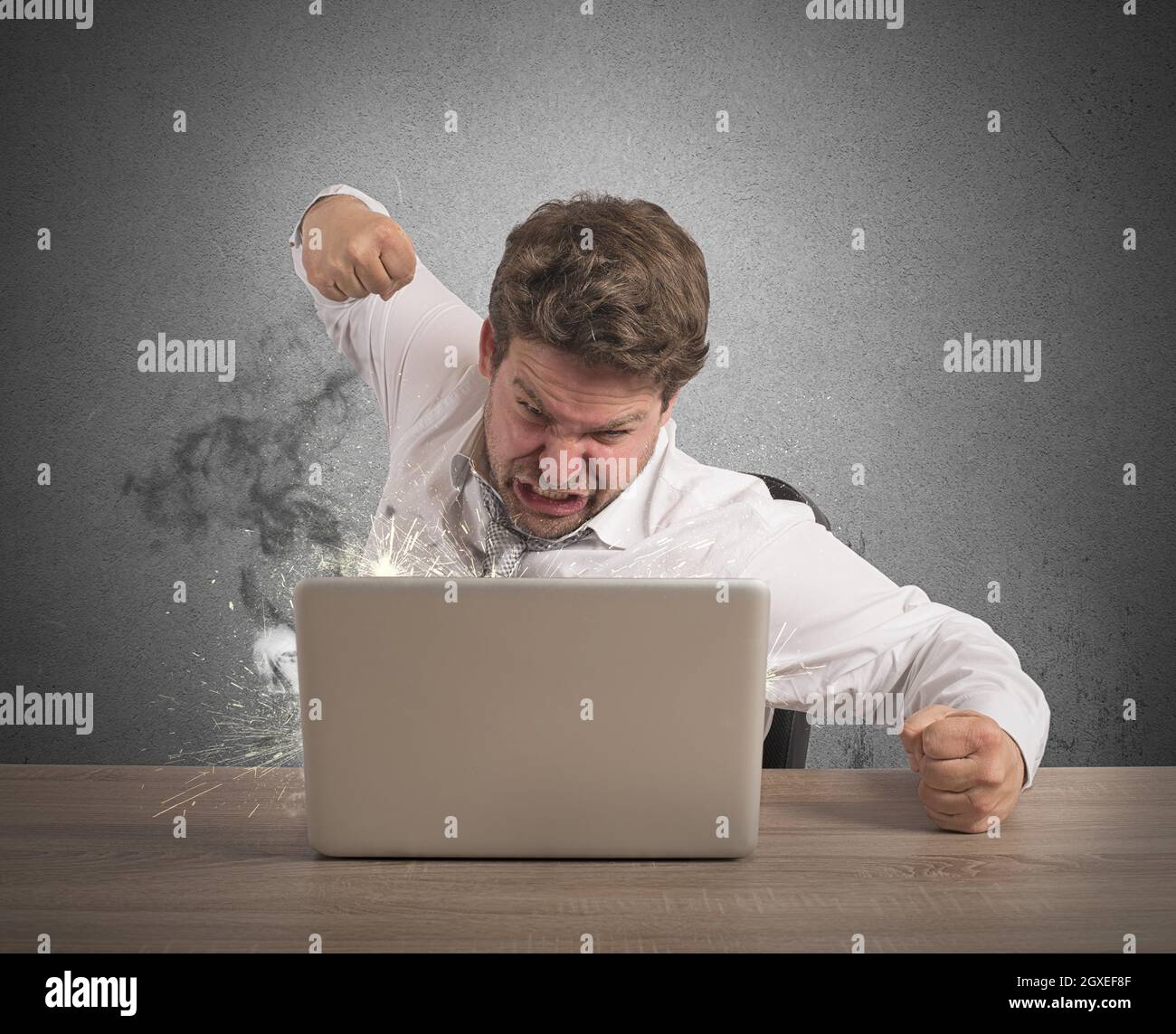 Stressed businessman breaks the computer with punch Stock Photo - Alamy