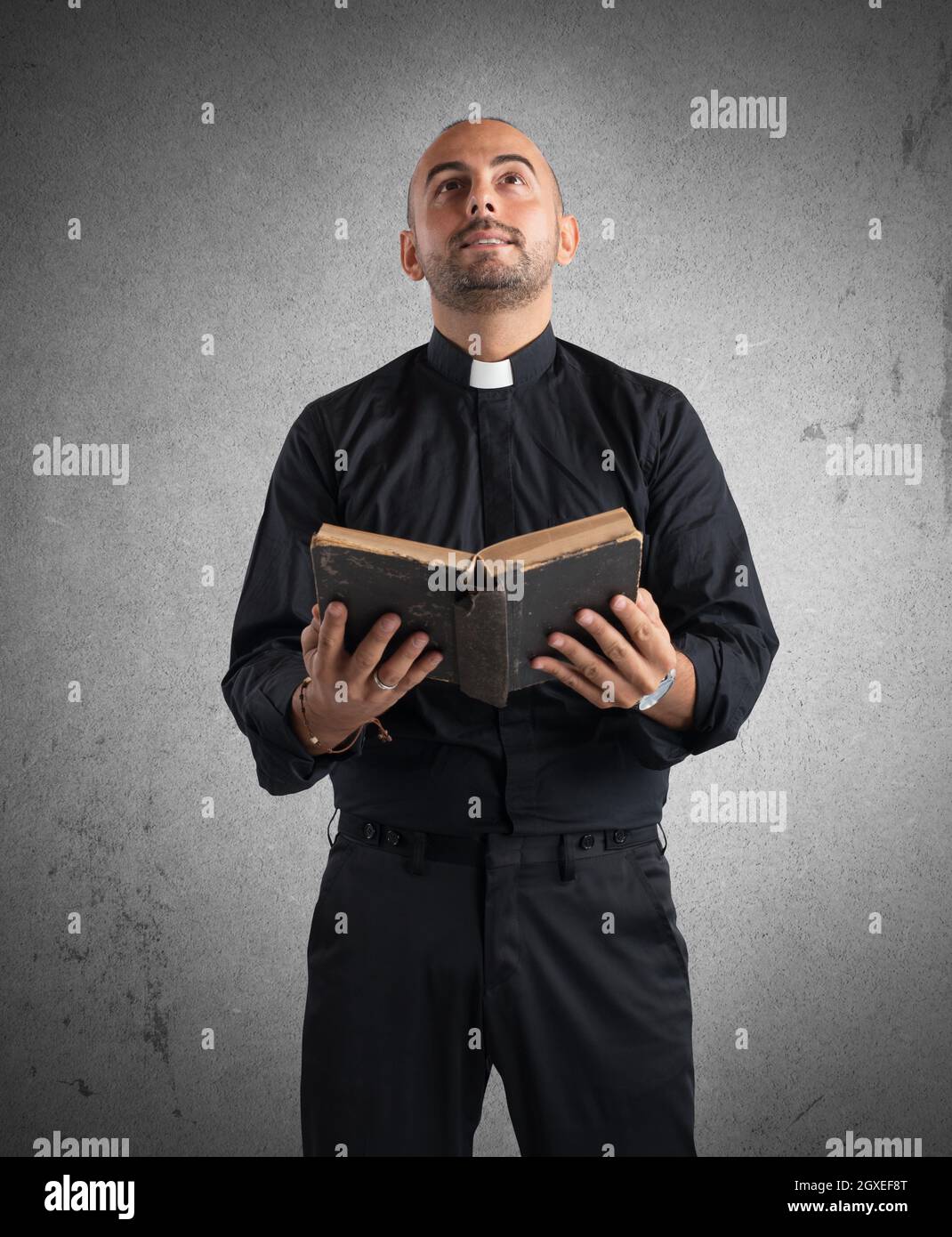 Priest praying and reading the sacred scripture Stock Photo - Alamy